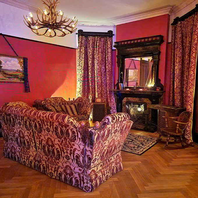Plush Victorian seating arranged before an ornate fireplace creates the perfect setting for ghost stories – or for becoming one yourself.