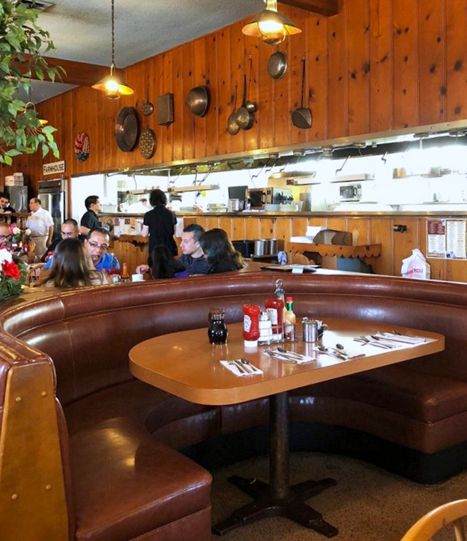 Those vintage booths have cradled more breakfast enthusiasts than a memory foam mattress, with copper pans watching from above like culinary guardian angels.