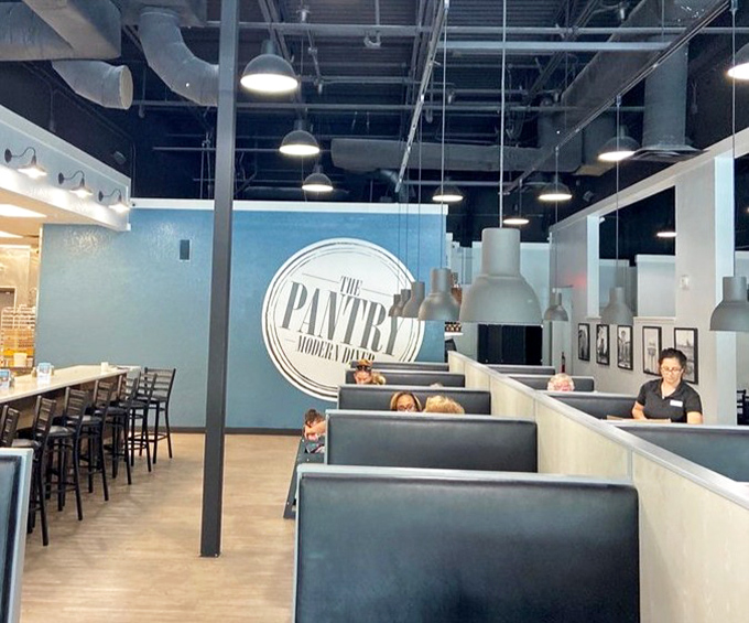 The blue accent wall and sleek booths create a modern twist on classic diner aesthetics. Retro meets contemporary in perfect harmony.