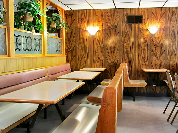 Pink booth seating and wood paneling create that perfect nostalgic vibe where calories don't count and pizza tastes like childhood.