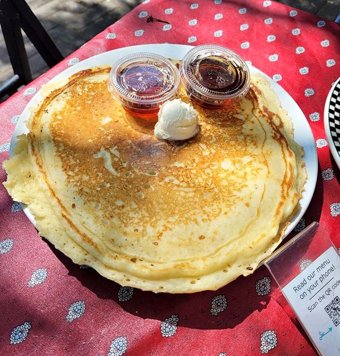 This pancake is so perfectly golden it belongs in Fort Knox. Two kinds of syrup because life's too short for single-condiment breakfasts.