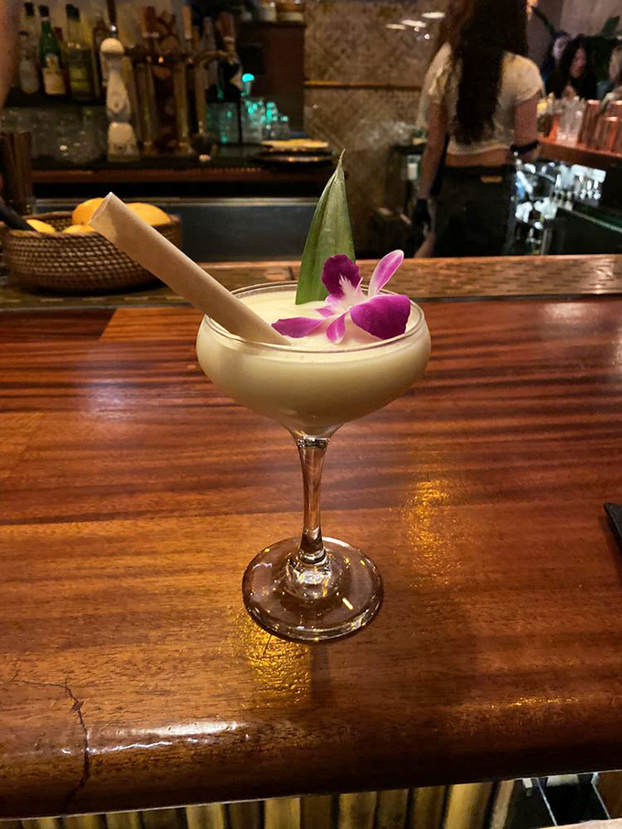 This tropical cocktail doesn't just transport you to vacation mode – it brings the vacation to you, complete with an orchid garnish.