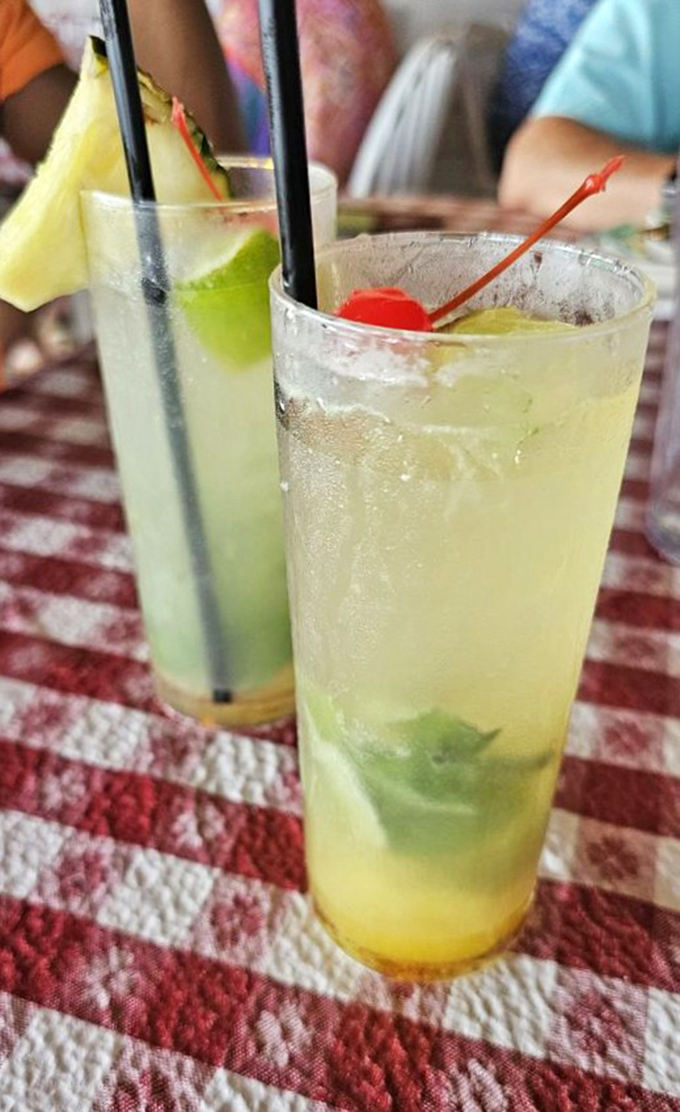 Cocktails that look like Florida sunshine in a glass. These mojitos aren't just drinks; they're vacation spirit guides with fruit hats.