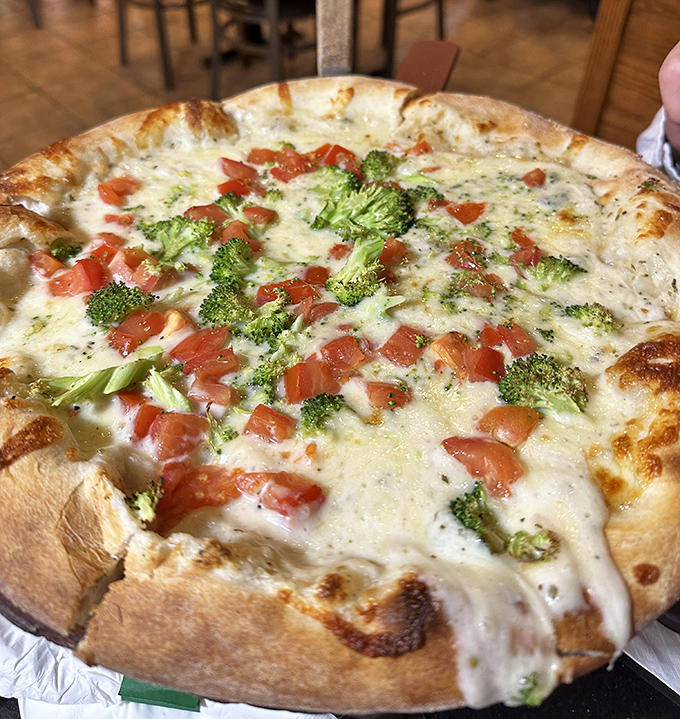 A white pizza that proves sometimes less is more. Broccoli and tomato playing so nicely together, they deserve a parenting award.