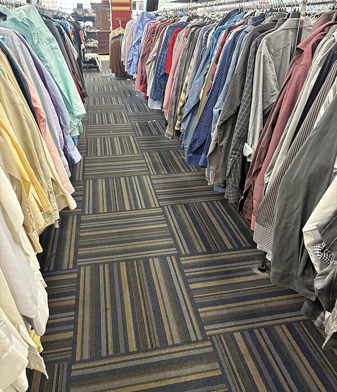 Clothing racks create canyons of possibility. Those pastel shirts are the unofficial Florida retiree uniform, available at a fraction of department store prices.