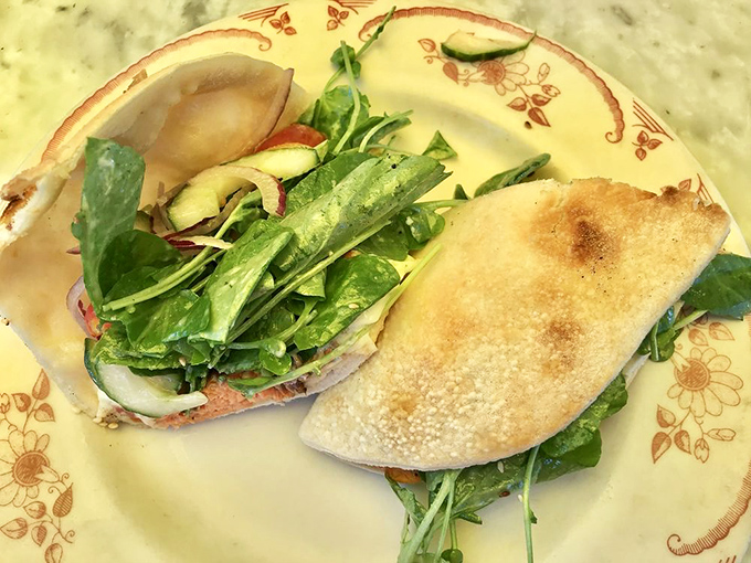 A sandwich that understands the importance of proper bread-to-filling ratio. Fresh greens and savory fillings nestled in a pocket of carb perfection.