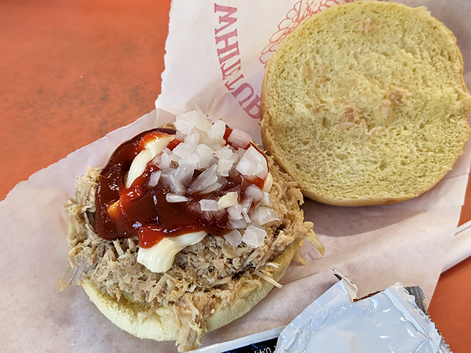 A pulled pork sandwich that doesn't hide behind pretension&mdash;just tender meat, tangy sauce, and diced onions creating a three-part harmony of flavor. 