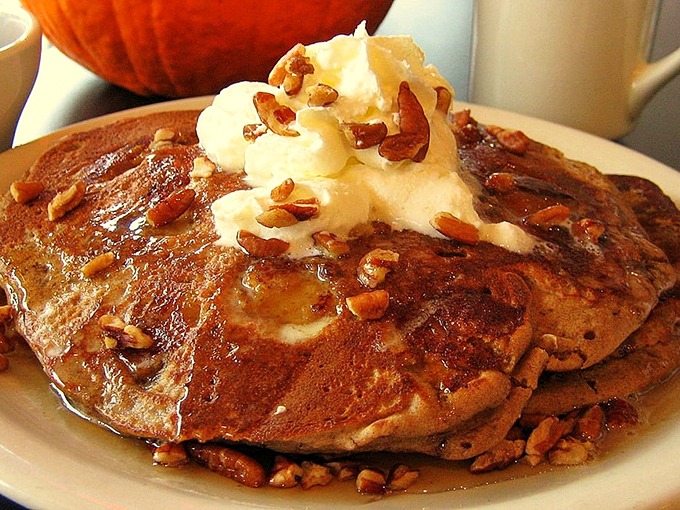 Pancakes so fluffy they could double as pillows, crowned with a melting pat of butter and pecans. Maple syrup's dream dance partner.