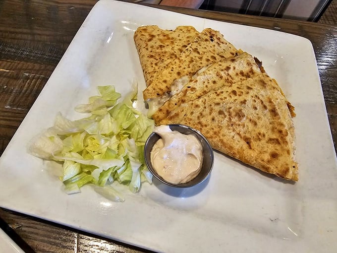 This quesadilla isn't playing games &ndash; golden-brown, stuffed with promises, and that dipping sauce is definitely not an afterthought.