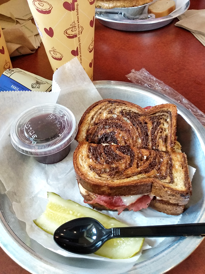 Marble rye embracing pastrami like long-lost lovers. This Reuben isn't just a sandwich&mdash;it's a relationship worth committing to.
