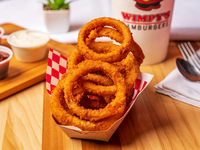 Onion rings stacked like golden halos &ndash; crispy, substantial, and demanding to be the main event rather than a mere side dish.