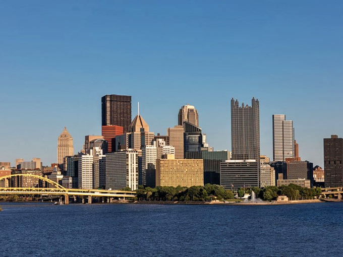 Pittsburgh's skyline stands in stark contrast to Brownsville's quieter profile, though both communities share Monongahela River waters and industrial histories.