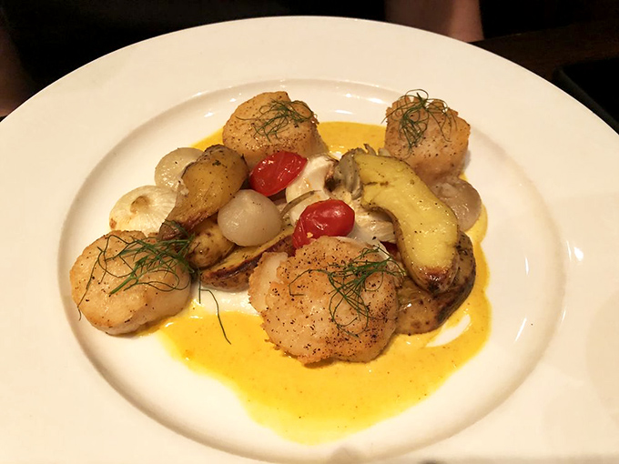 These perfectly seared scallops, surrounded by seasonal vegetables in a golden sauce, are like ocean-fresh butter bombs that melt in your mouth.