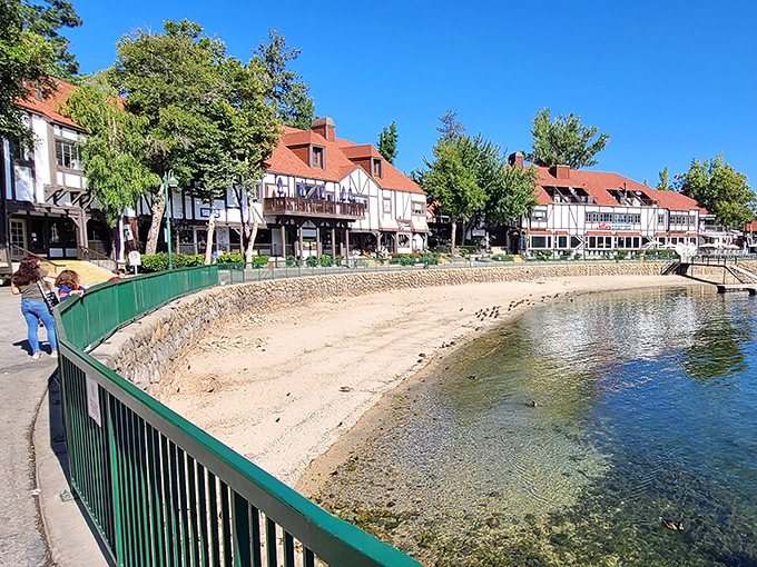 A peaceful shoreline moment where crystal-clear waters meet the village boardwalk. That little beach practically begs for a picnic.