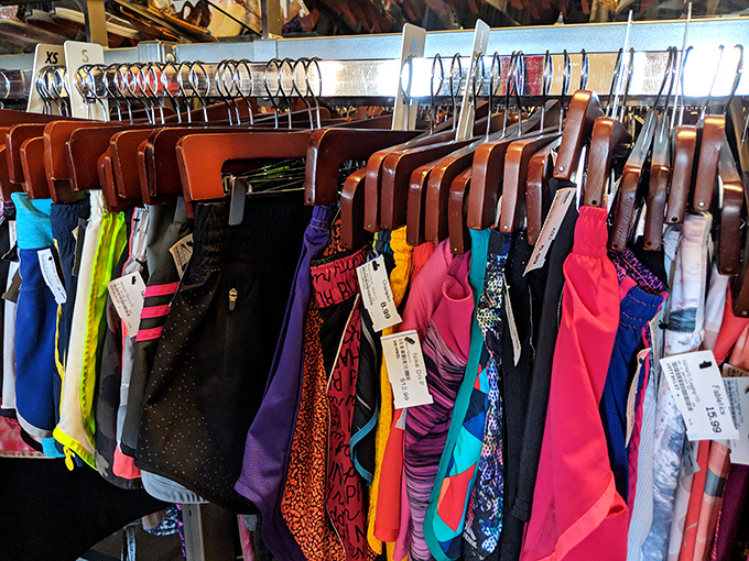 The technicolor dream rack! Athletic wear that's barely broken a sweat hangs in vibrant formation, waiting for its next adventure.