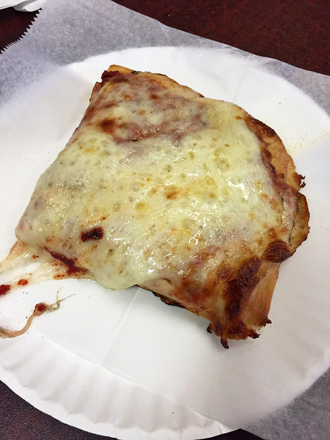 The Sicilian slice: a thick, pillowy canvas of dough supporting a perfect ratio of cheese and sauce. Carb heaven exists.