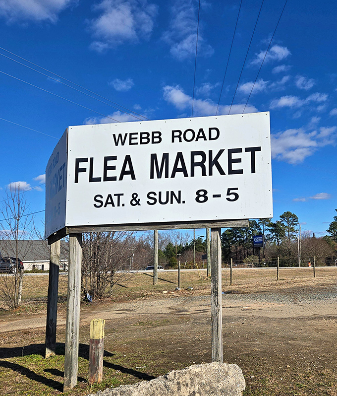 The no-frills roadside sign announces weekend hours with the straightforward promise of treasures that need no fancy advertising.