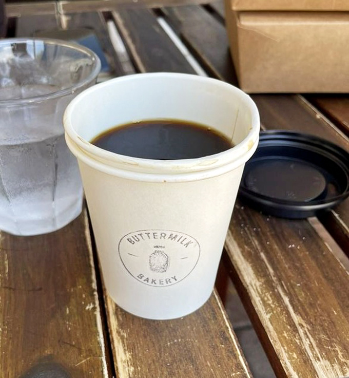 Even the coffee cups wear the Buttermilk Bakery logo with pride, holding liquid fuel for pastry adventures.