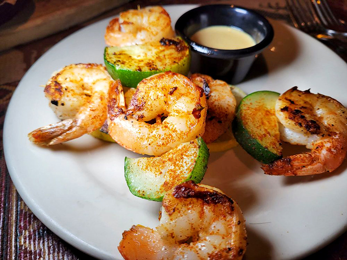 Grilled shrimp nestled against zucchini slices &ndash; seafood that tastes like it just jumped from ocean to grill. Simple perfection needs no disguise.