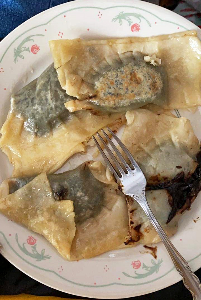 Someone's taken a fork to these spinach-filled treasures, and honestly, who could blame them? The thin dough reveals the emerald filling within.