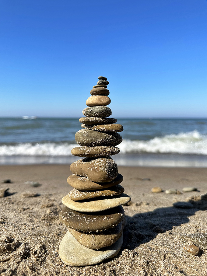 Balanced stones stand in perfect harmony, a meditative practice that requires more patience than waiting for your turn at the ice cream stand.