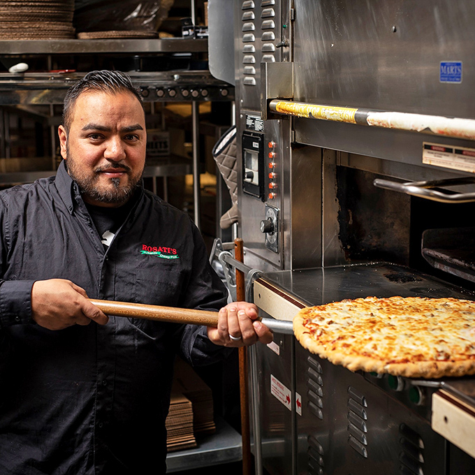 Pizza artisans at work&mdash;where wooden paddles are extensions of hands and ovens are portals to deliciousness.