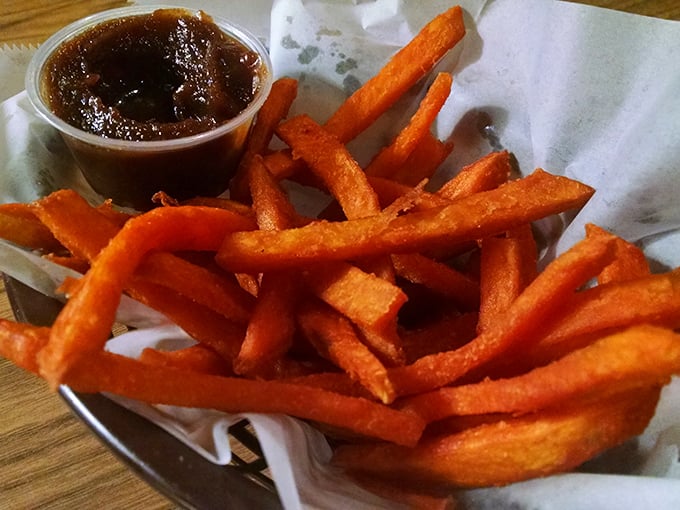 Sweet potato fries with attitude—vibrant orange soldiers of satisfaction lined up beside their dipping sauce companion, ready for duty.