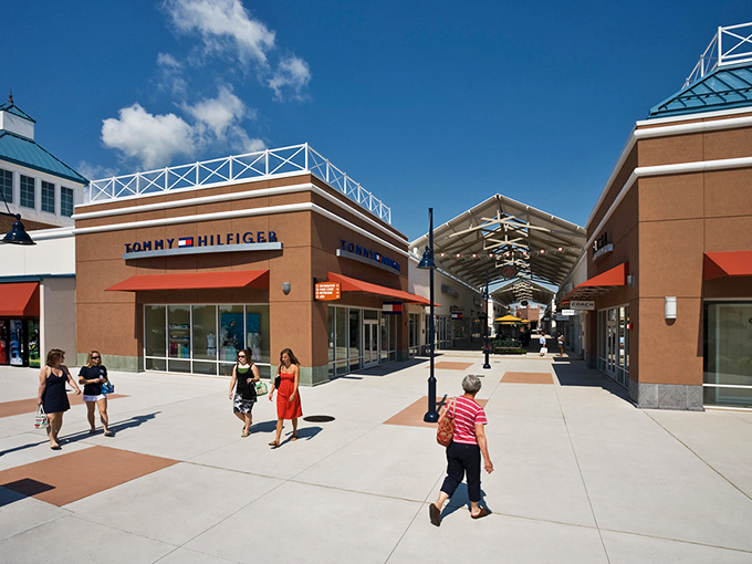 Tommy Hilfiger stands proud under brilliant blue skies, while shoppers crisscross the plaza like bargain-hunting honeybees moving from one sweet deal to the next. 