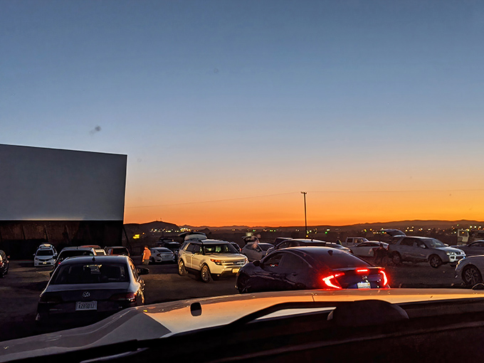 Sunset bathes the parking area in golden light as vehicles claim their spots for the evening's entertainment.