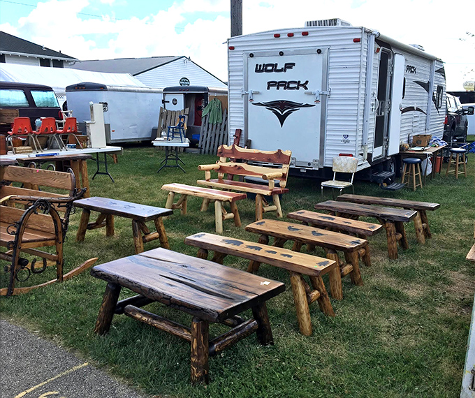 Rustic benches lined up like wooden soldiers, each with its own personality. Handcrafted from logs that have stories to tell about Wisconsin forests.