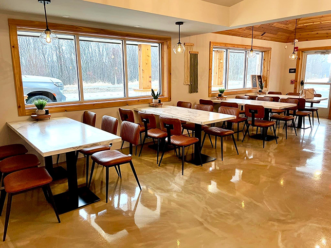 Large windows flood the space with natural light, creating an atmosphere where food and conversation flow equally well across polished tables.