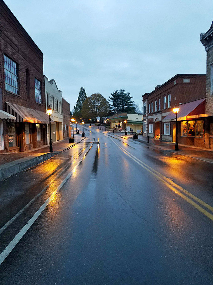 Rain-slicked streets reflect the warm glow of storefronts, creating an accidental masterpiece that even the best Instagram filter couldn't improve upon.