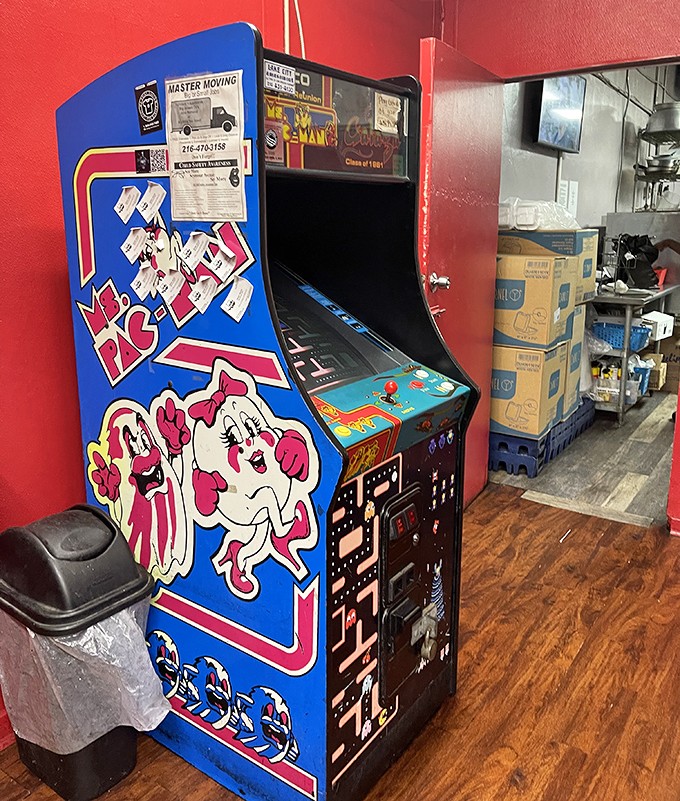 Where nostalgia meets hunger: the vintage arcade machine standing guard like a sentinel from simpler times.