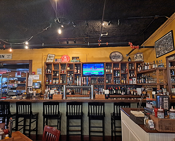 The bar isn't just serving drinks; it's preserving history. Bottles line up like soldiers against golden walls where vintage signs tell stories of Tennessee's spirited past.