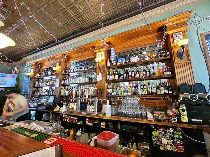 A bar stocked with enough options to make decision-making the hardest part of your visit. Those string lights aren't just decorative&mdash;they're mood medicine.