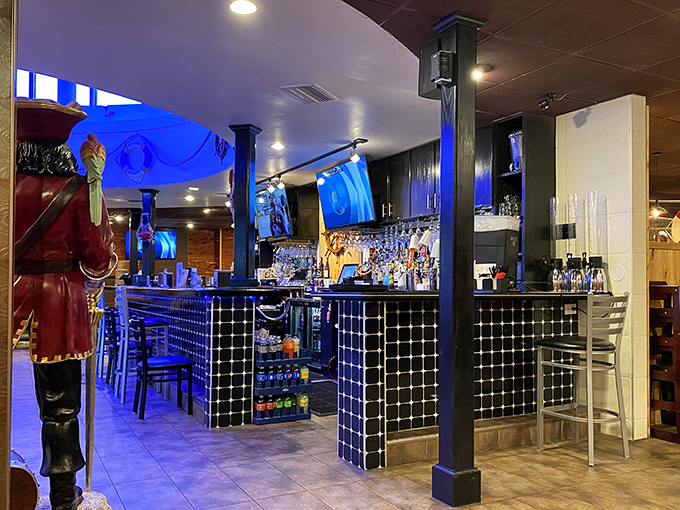 Blue lighting transforms the bar area into an underwater grotto where cocktails flow like treasure from a sunken galleon.