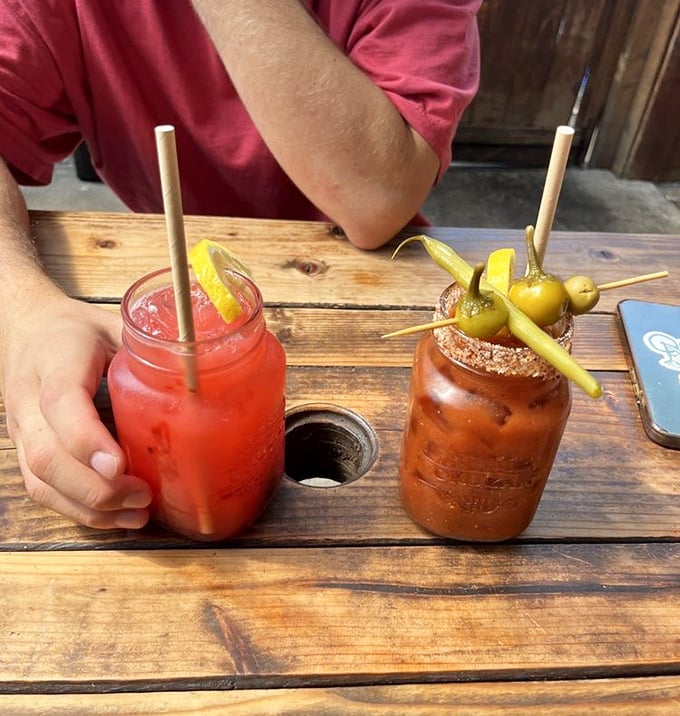 Portland brunch culture in two glasses: a vibrant berry lemonade and a Bloody Mary garnished with enough snacks to count as an appetizer.