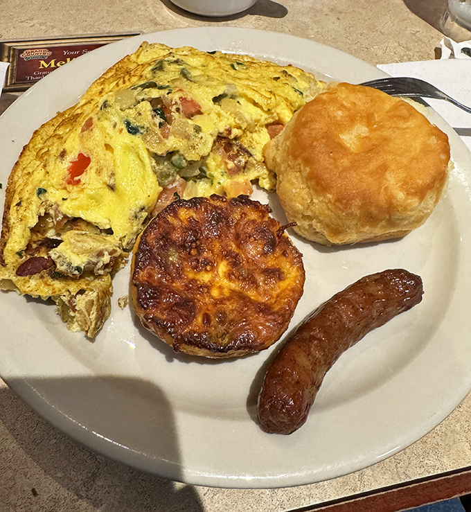 Breakfast done right: a fluffy omelet, golden biscuit, and sausage link that make waking up early almost worth it&mdash;almost.