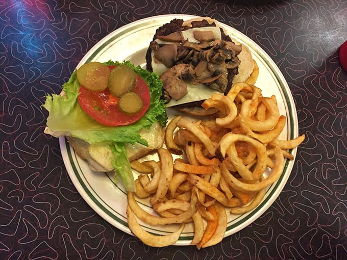 A classic diner burger with a mountain of curly fries &ndash; proof that sometimes the simplest pleasures are the ones that keep us coming back for more.