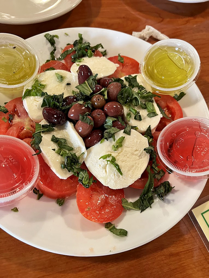 A caprese salad that understands the assignment: fresh mozzarella, ripe tomatoes, and olives that weren't born in a can.
