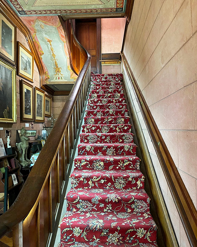 The grand staircase with its rich red carpet invites you upward, though climbing it in period-appropriate clothing would qualify as today's cardio workout.