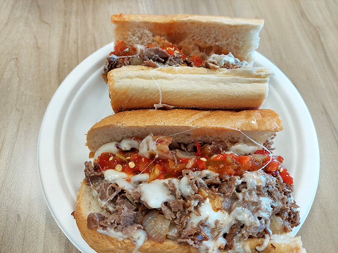 The cheesesteak arrives dressed in melted cheese and hot peppers like it's ready for sandwich prom.