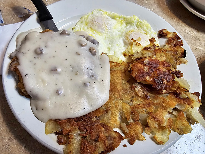 Chicken fried steak smothered in gravy with eggs and hash browns&mdash;a plate that says "you won't need dinner" in the most delicious way possible.