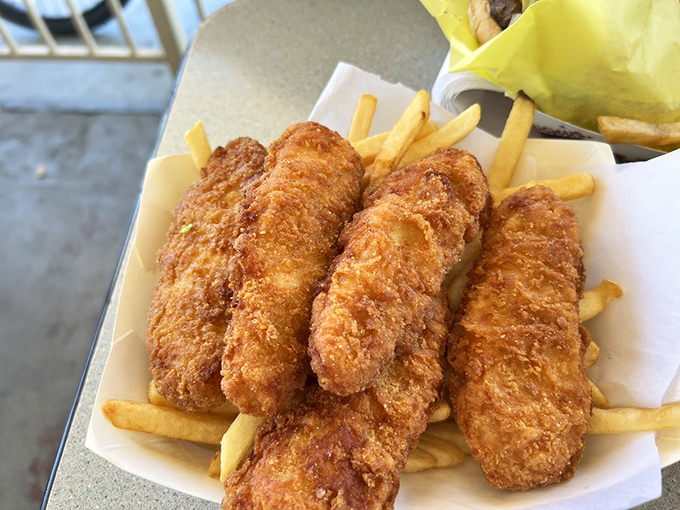 Golden-fried chicken tenders that could make Colonel Sanders question his life choices, served with fries that understand their supporting role.