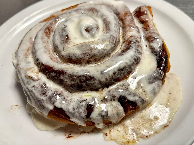 This cinnamon roll isn't just breakfast&mdash;it's dessert masquerading as morning food, swimming in a pool of glorious icing.