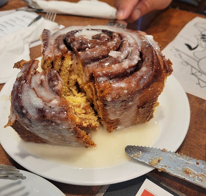 This cinnamon roll isn't just big &ndash; it's the "needs its own zip code" kind of massive, with swirls of cinnamon and glaze pooling beneath.
