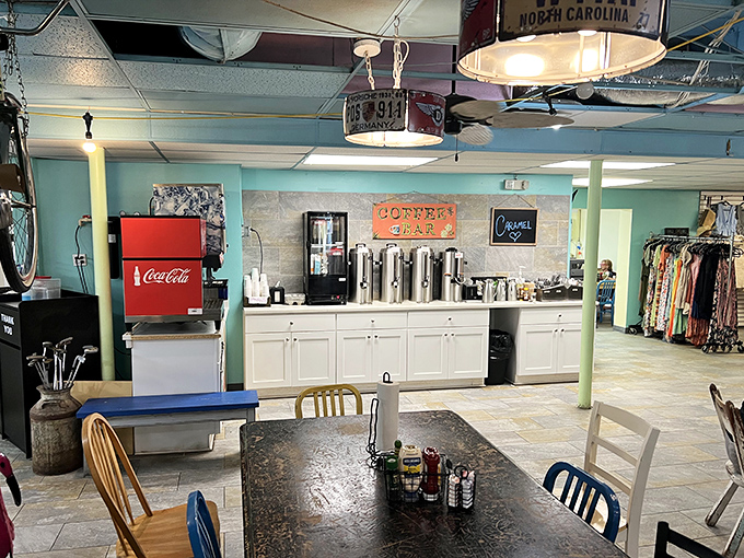 The coffee station stands ready like a caffeinated oasis, promising liquid motivation beneath vintage license plates and hand-painted signs.