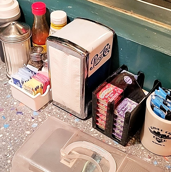 Every table's little civilization center&mdash;napkins, sweeteners, and that classic metal napkin dispenser that's somehow survived decades of technological advancement. 