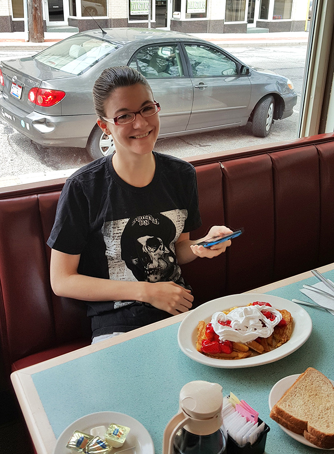 The look of anticipation before diving into what appears to be a fruit-topped waffle creation. Some moments are worth pausing for a photo.