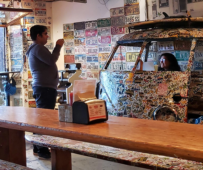 Inside Hodad's, where license plates become wallpaper and VW buses become d&eacute;cor. Even the furniture is having more fun than at your house.